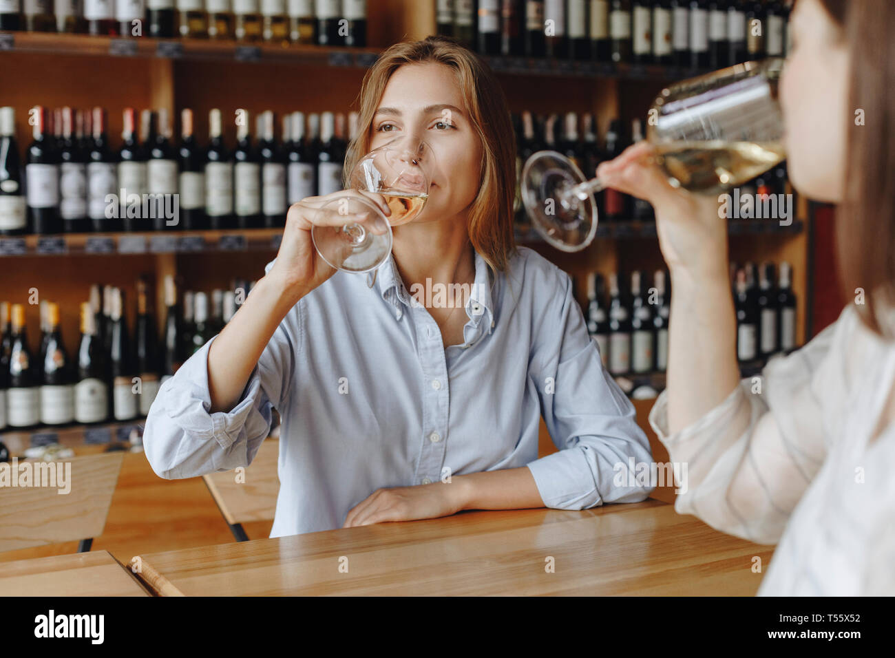 Young women drinking white wine Stock Photo - Alamy
