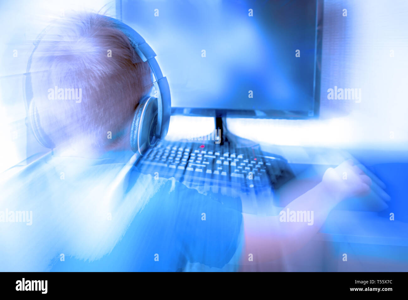 Teenager in a Headset Looking at Computer Screen, Playing Computer Game ...