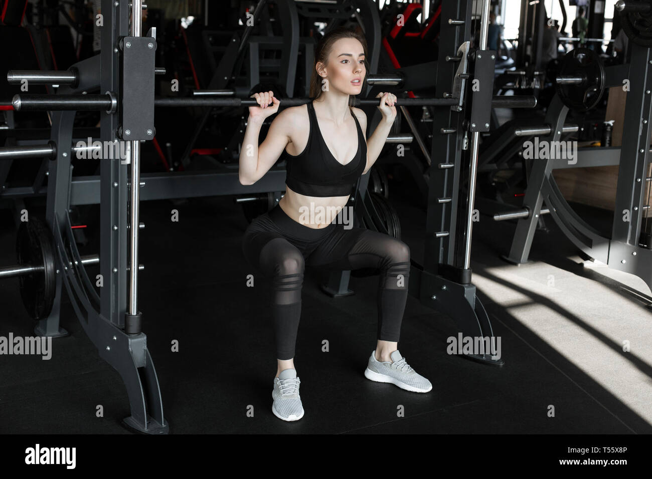 Young woman using exercise machine in gym Stock Photo - Alamy