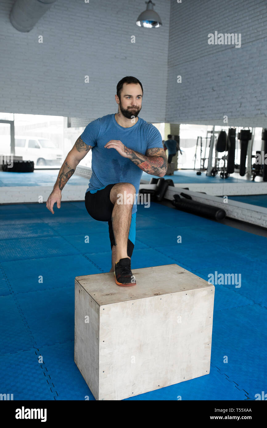 Man stepping onto box in gym Stock Photo - Alamy