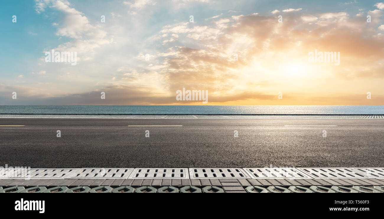 Empty asphalt road and blue sea with sky background Stock Photo - Alamy