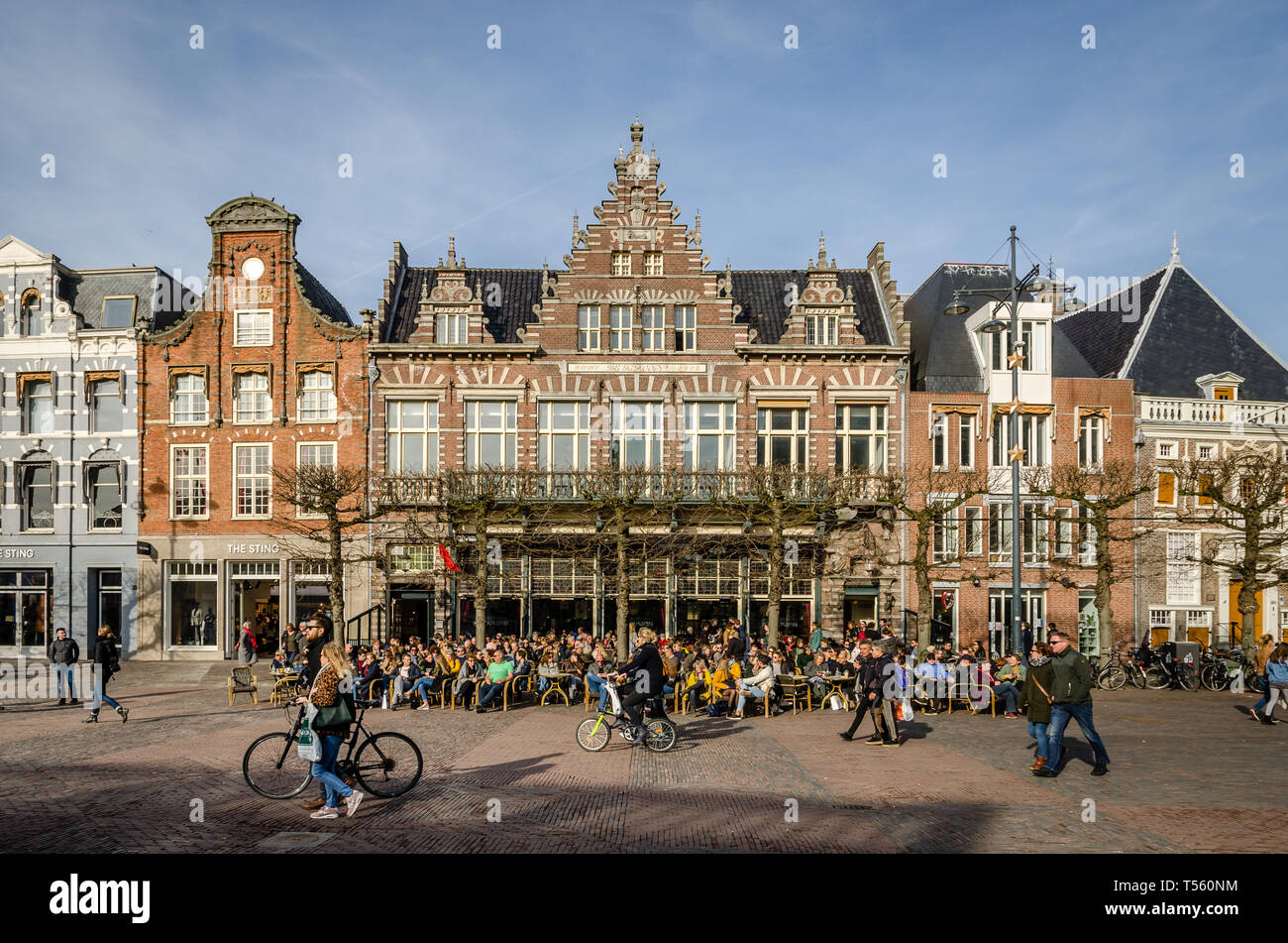 HAARLEM, NETHERLANDS - February 17, 2019: People relaxing on sidewalk ...