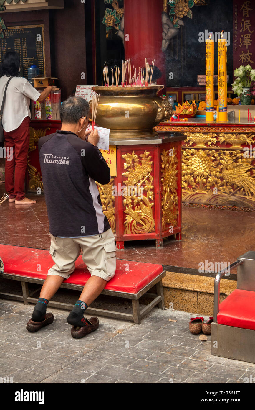Thailand, Bangkok, Chinatown, Thanon Yaowarat, Kuan Yim Shrine, man praying with incense sticks ...