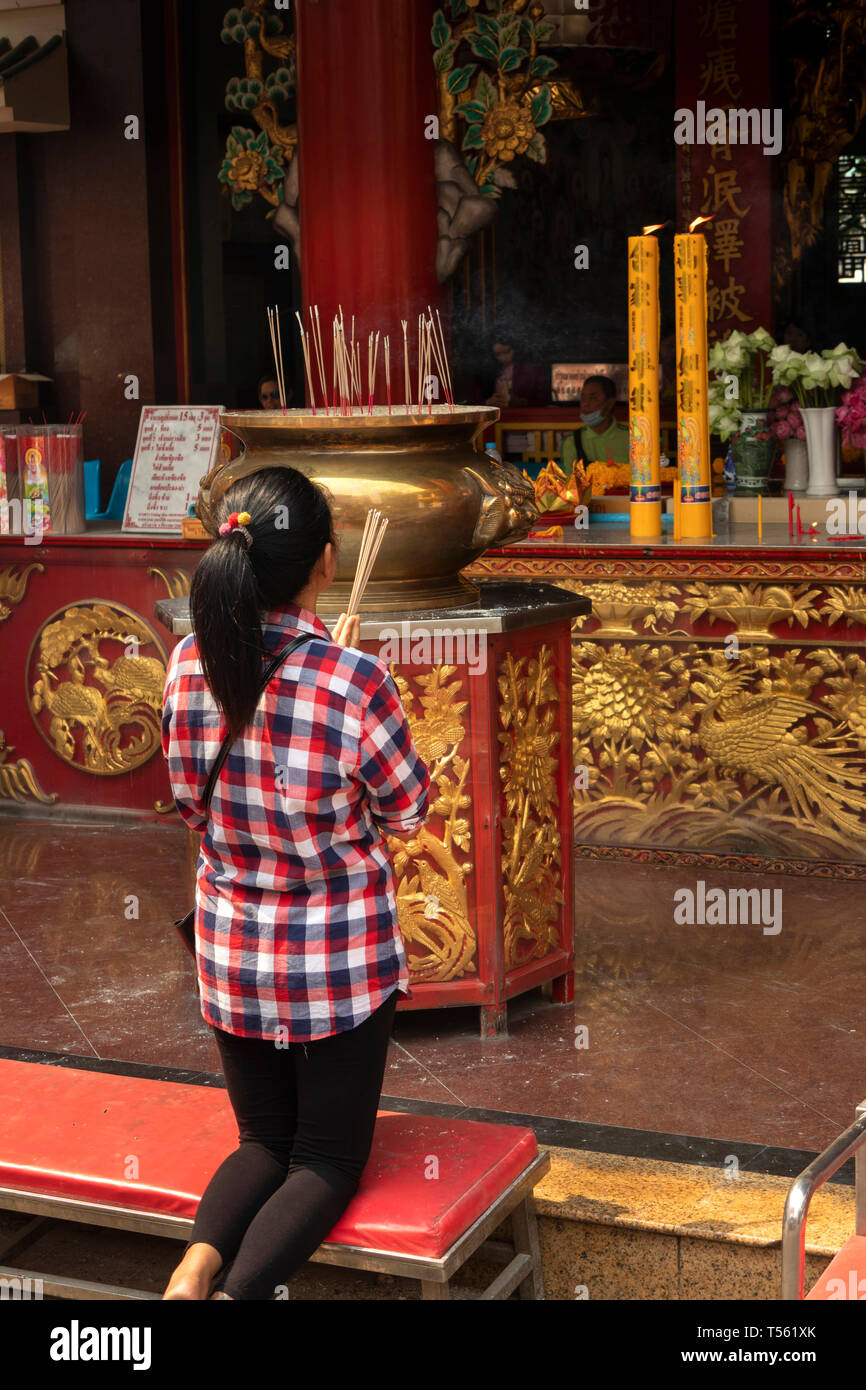 Thailand, Bangkok, Chinatown, Thanon Yaowarat, Kuan Yim Shrine, woman praying at candles with ...
