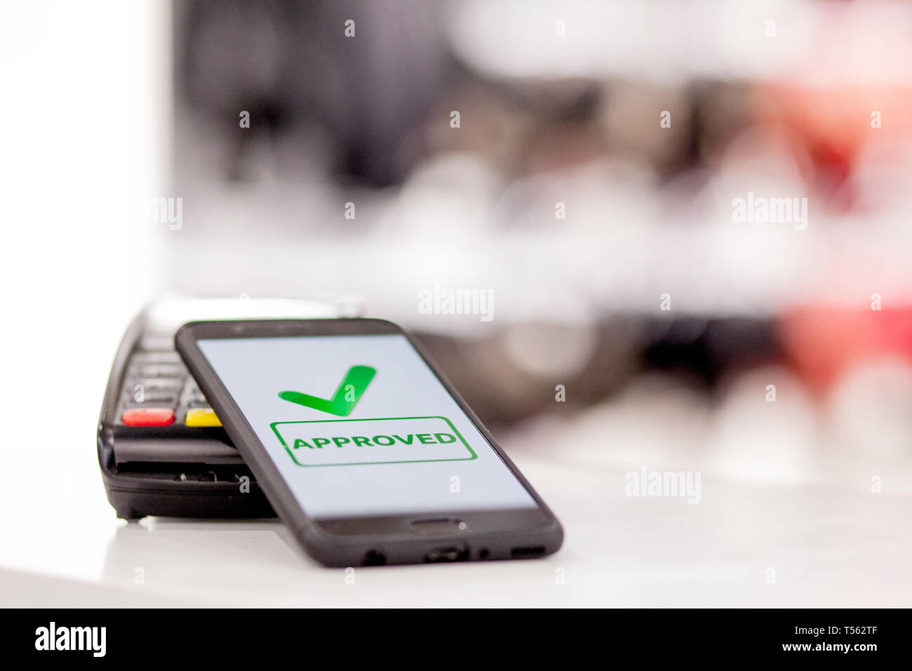 POS terminal, Payment Machine with mobile phone on store background ...