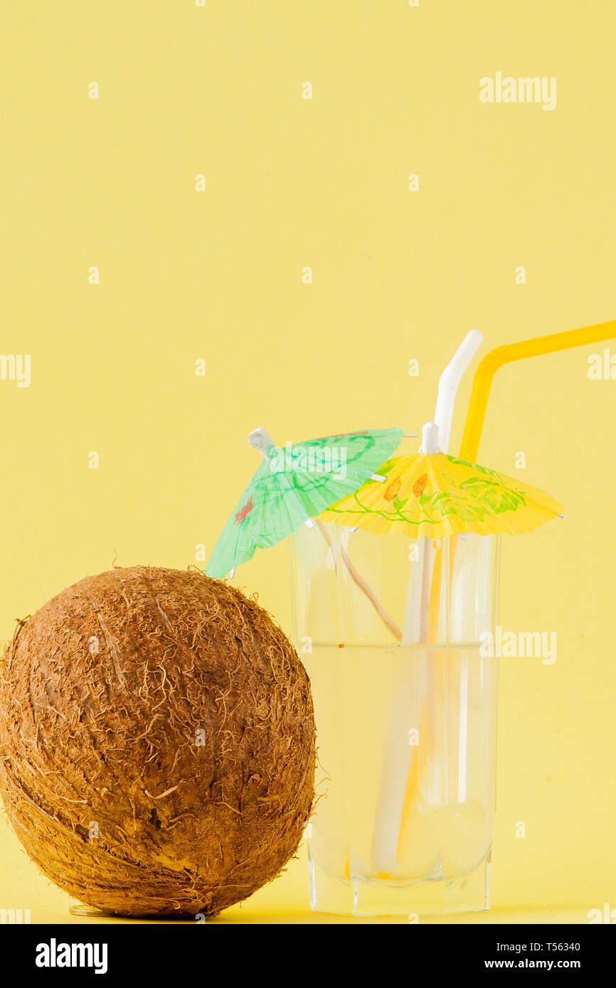 Fresh Coconut cocktail with a straws on yellow background, copy space ...