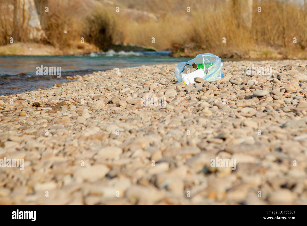 River pollution near the shore, garbage near the river, plastic food ...