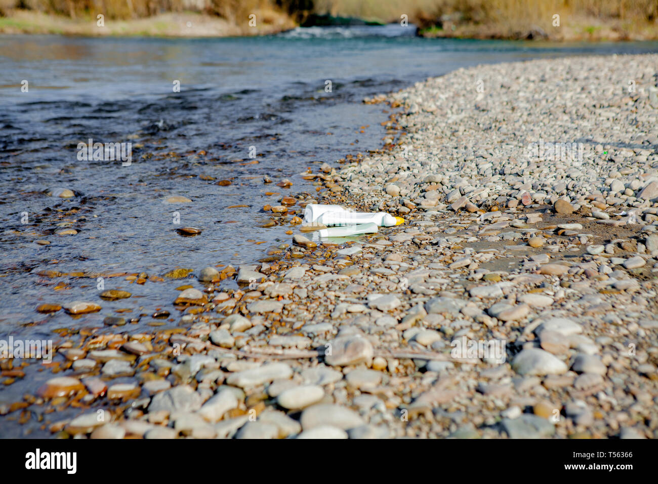 River pollution near the shore, garbage near the river, plastic food ...