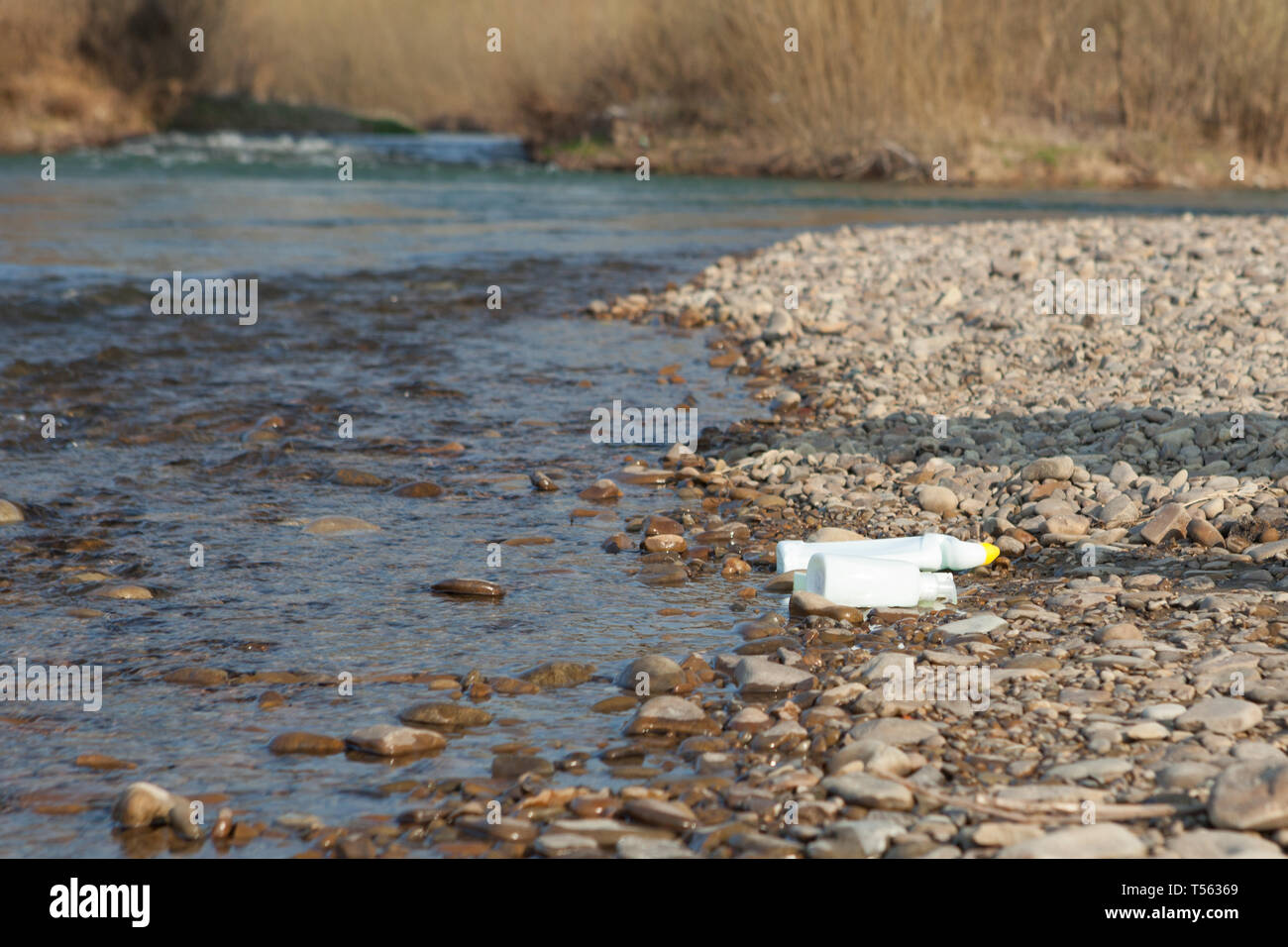 River pollution near the shore, garbage near the river, plastic food ...