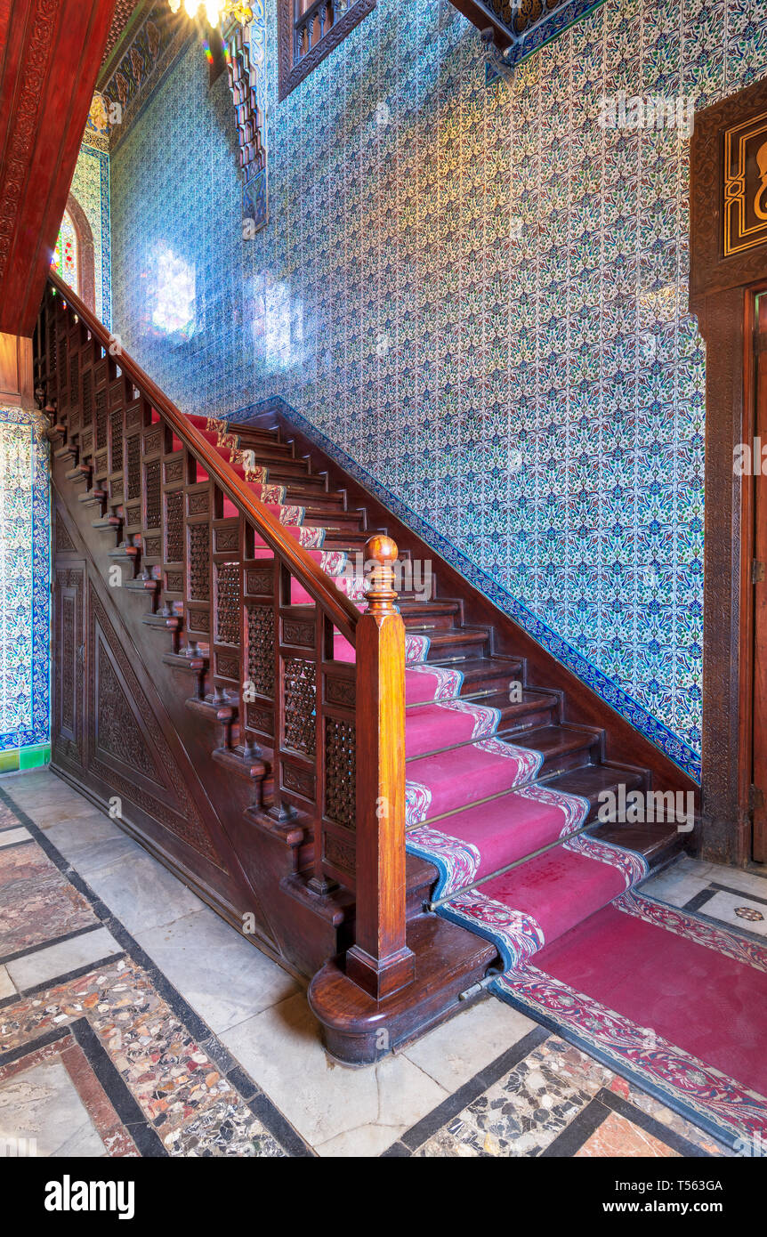 Wooden staircase with ornate red carpet, decorated wooden balustrade ...