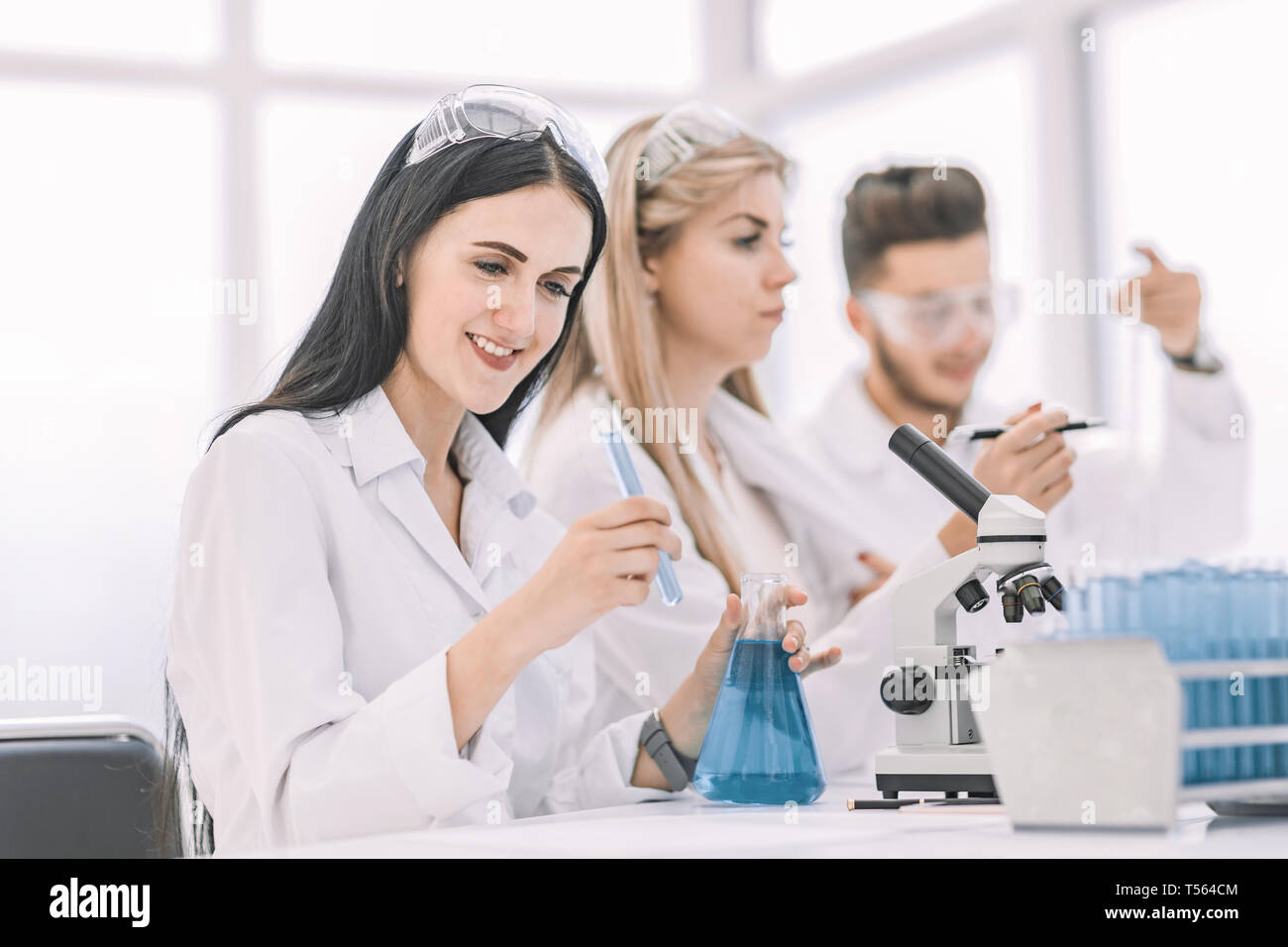 group of young scientists conduct research in the laboratory . science ...