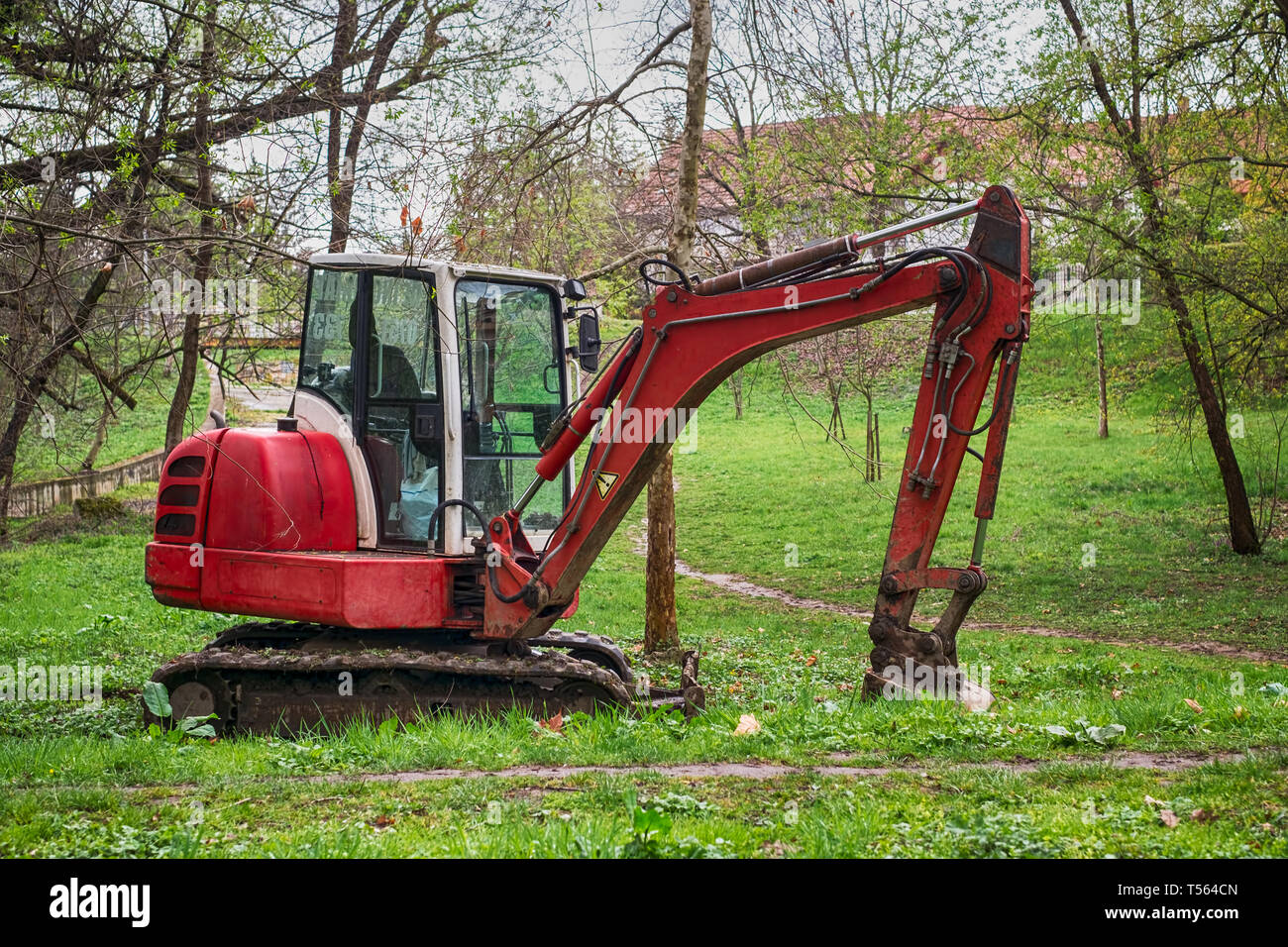 a small red excavator in the woods Stock Photo - Alamy