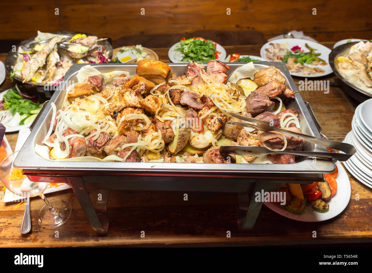 Grilled meat for a large company is on the table in the restaurant ...
