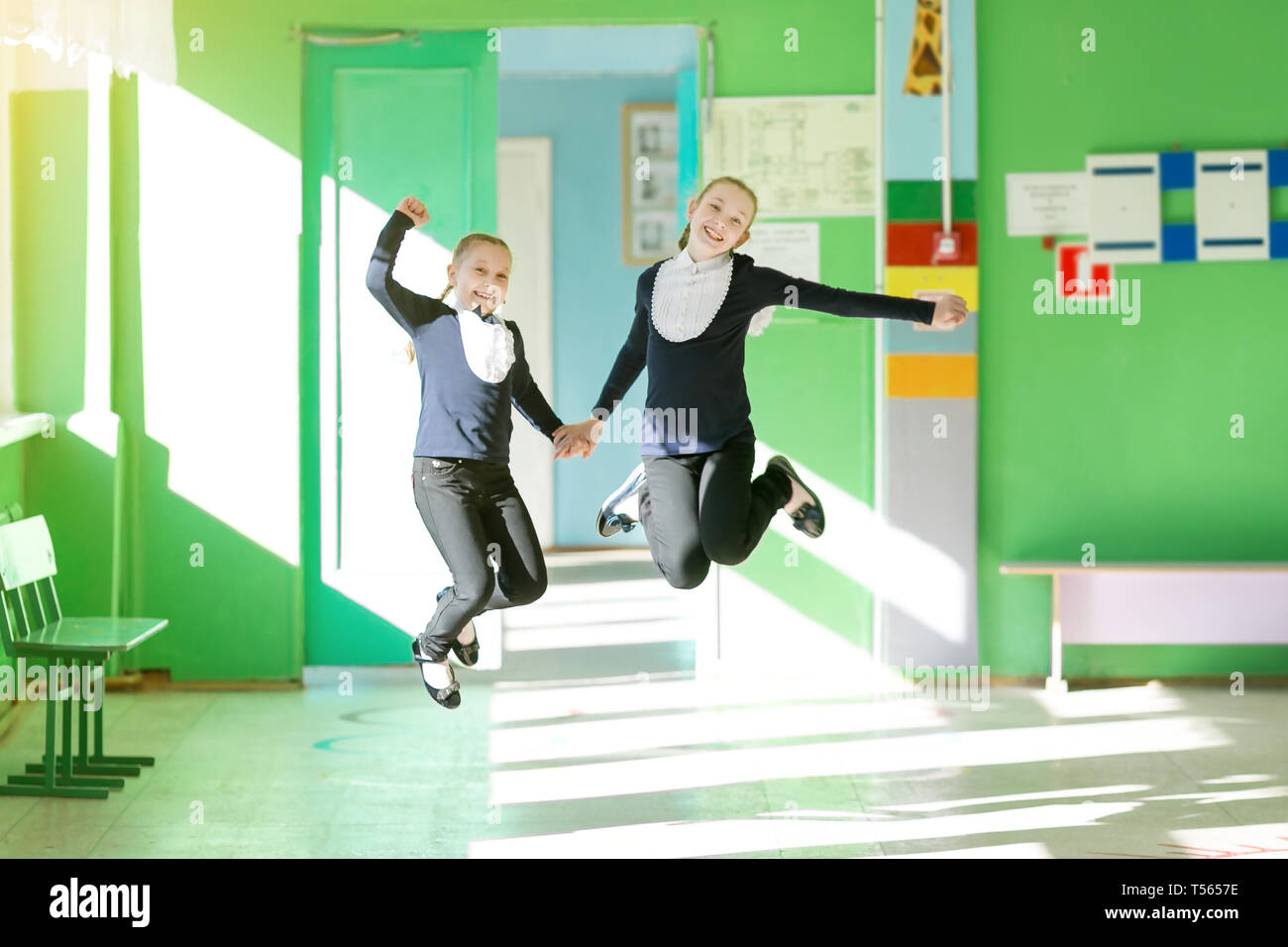 Schoolgirl girls jumping high are having fun at school recess Stock ...