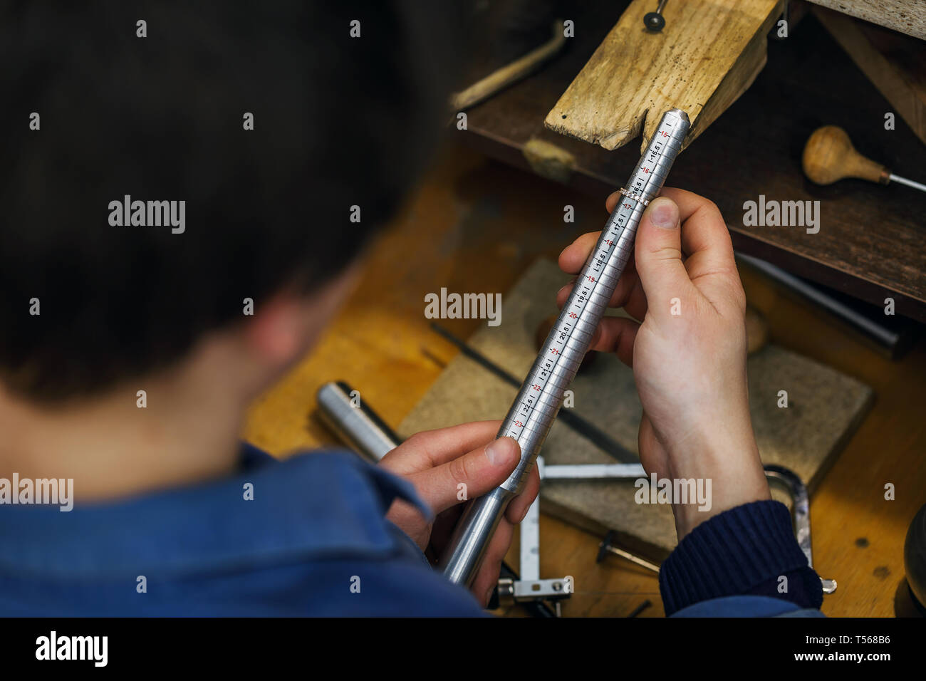 Jeweler determines the size of the ring on a special tool called a ring ...