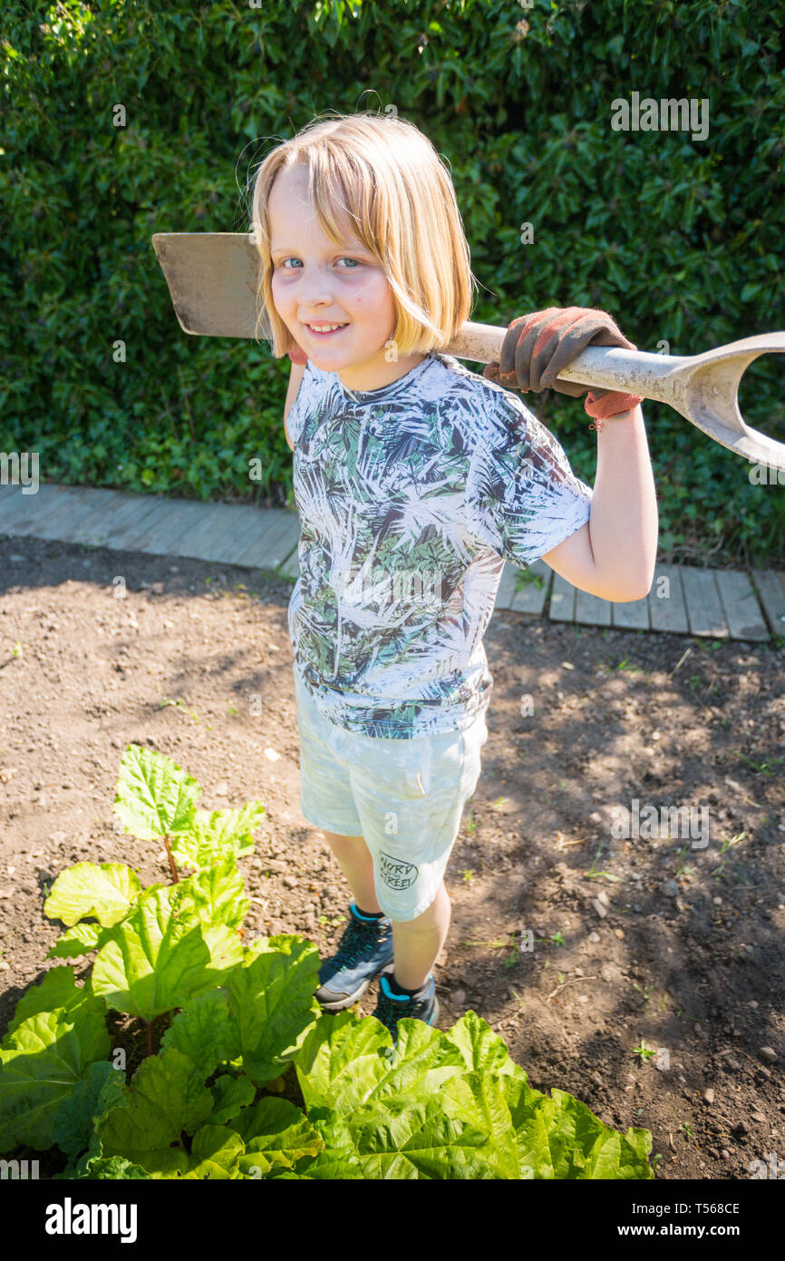 Ten year old girl holding a garden spade on an allotment UK Stock Photo ...
