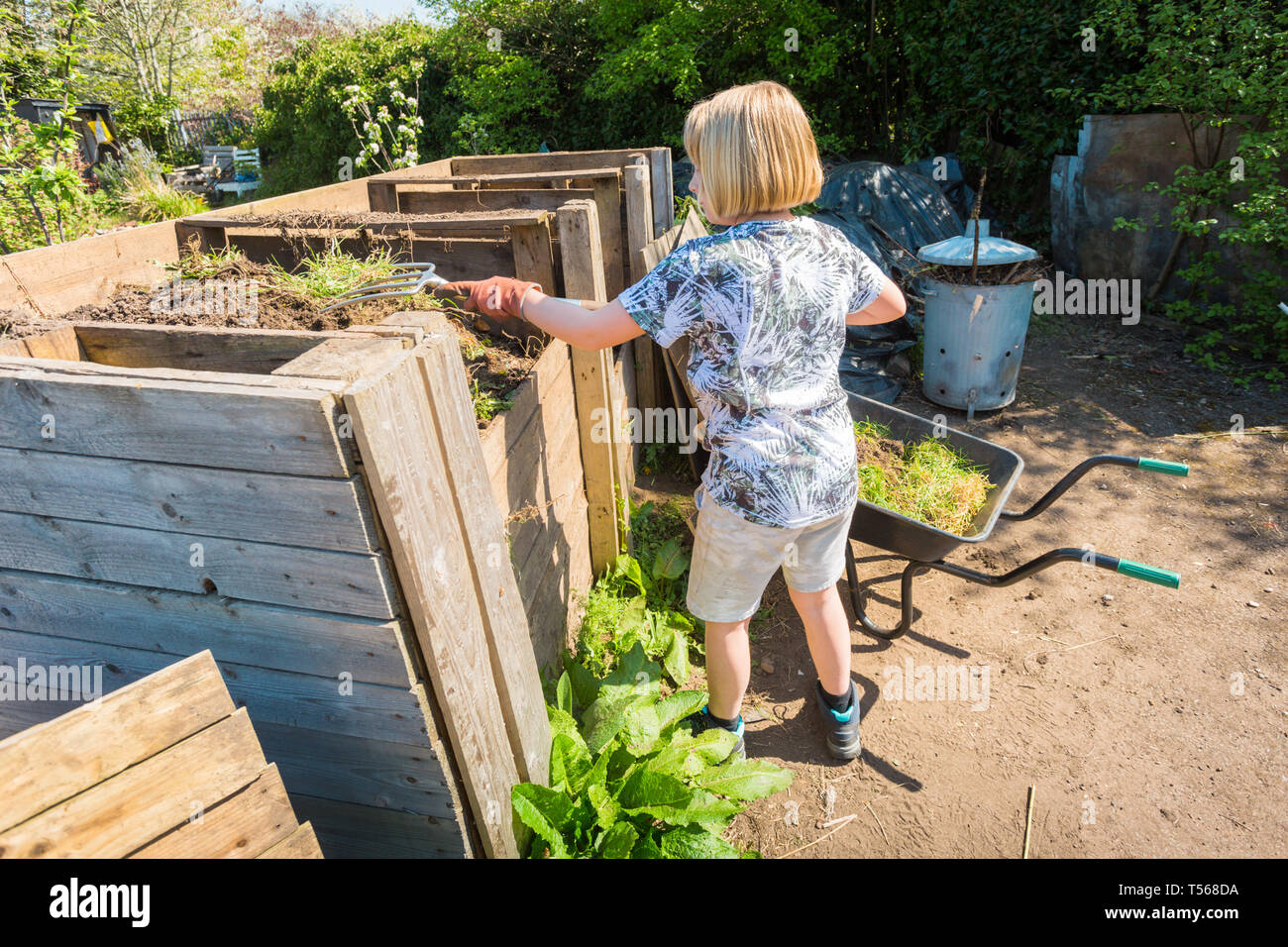 Ten year old girl working on an allotment compost heap UK Stock Photo ...