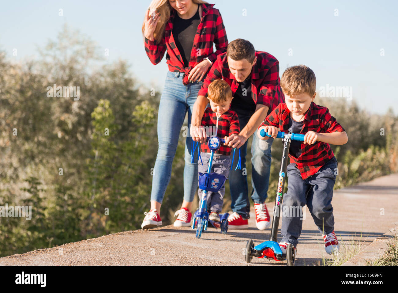 Young happy family with childrens having fun in nature. Happy kids ride ...