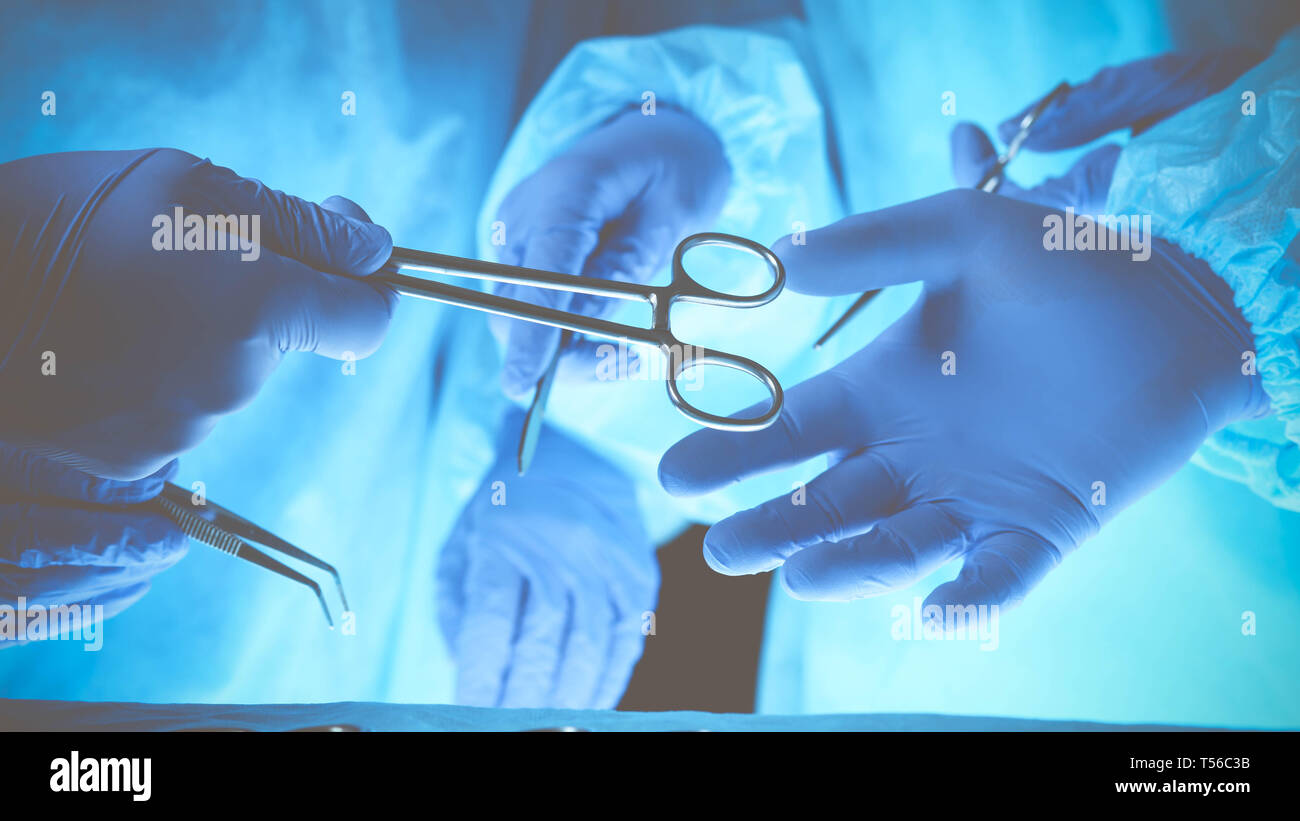 Surgeons hands holding surgical scissors and passing surgical equipment ...