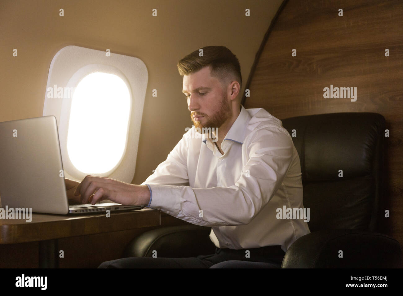 Young attractive and successful businessman working while sitting in ...