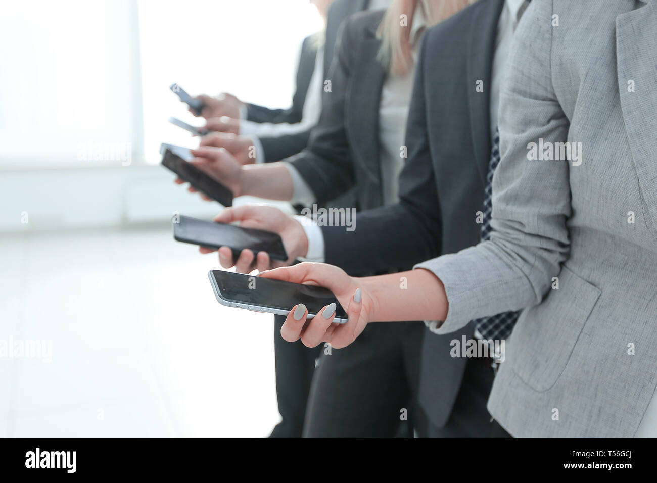 Group of people look at phones in arms at office closeup Stock Photo ...