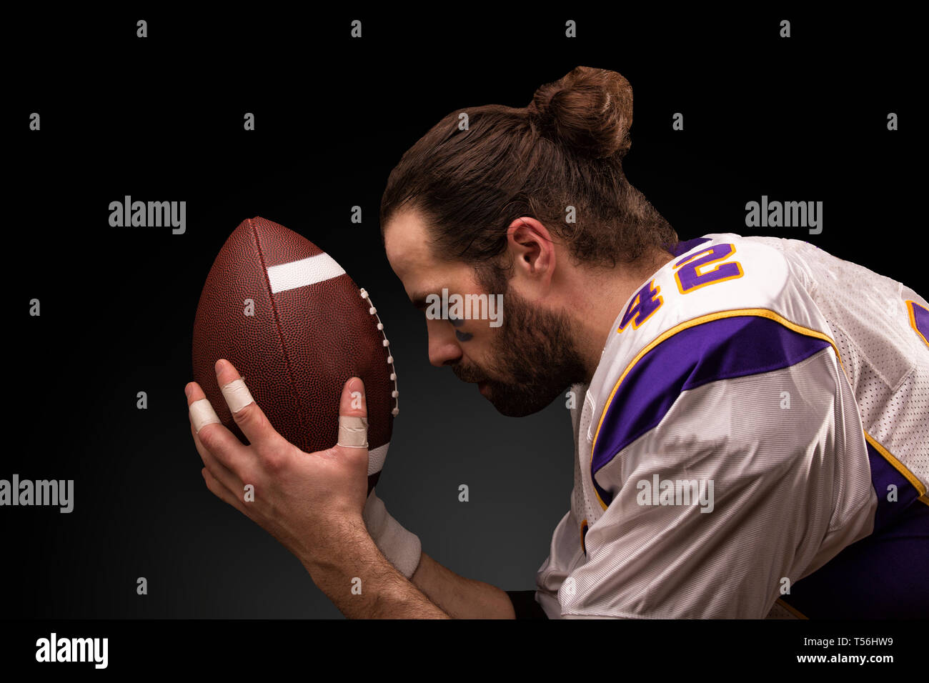 american football player with a ball On moment to pray before the game ...