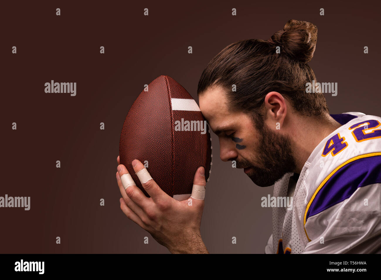 american football player with a ball On moment to pray before the game ...
