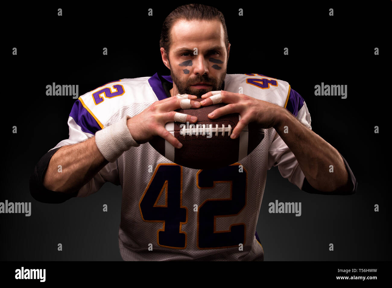 american football player with a ball On moment to pray before the game ...