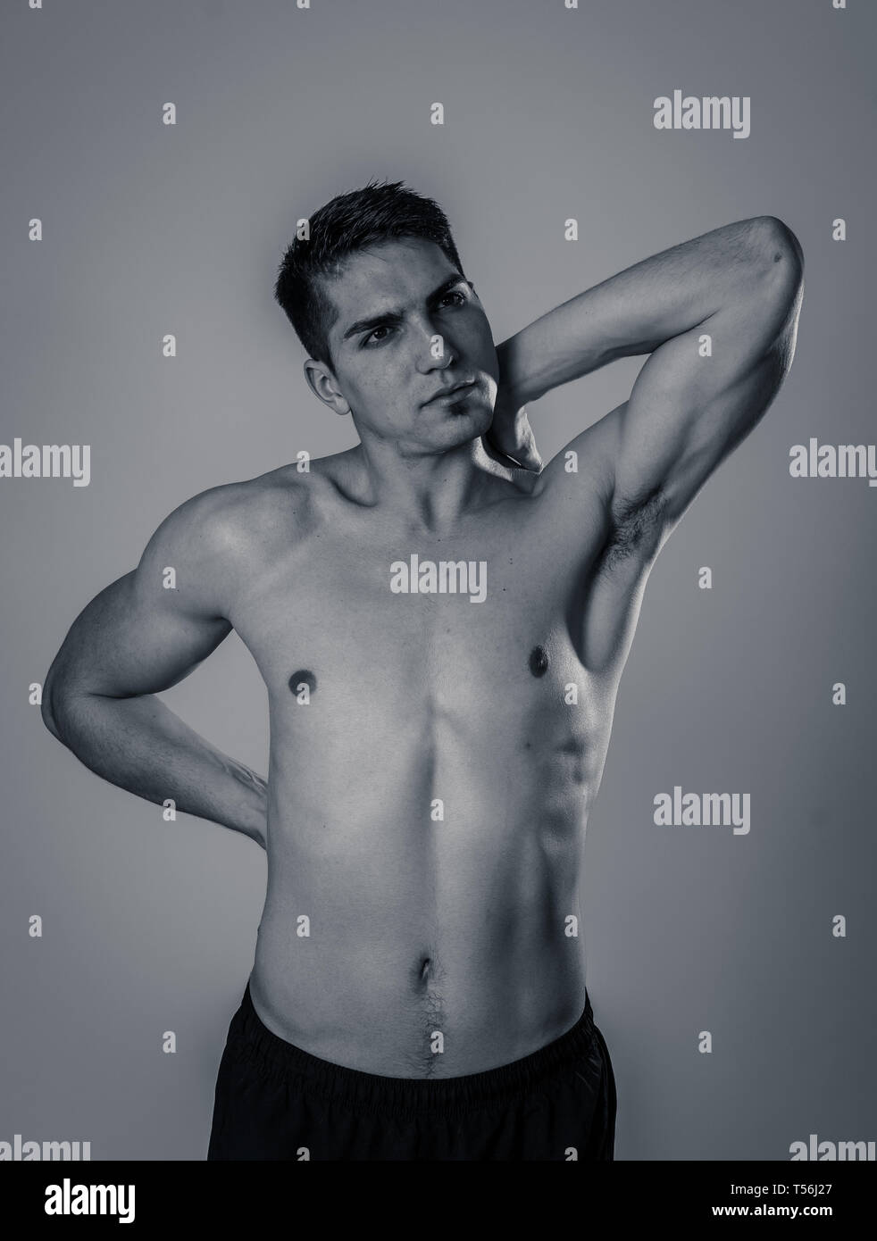 Young muscular fitness man touching and grabbing his neck and lower ...