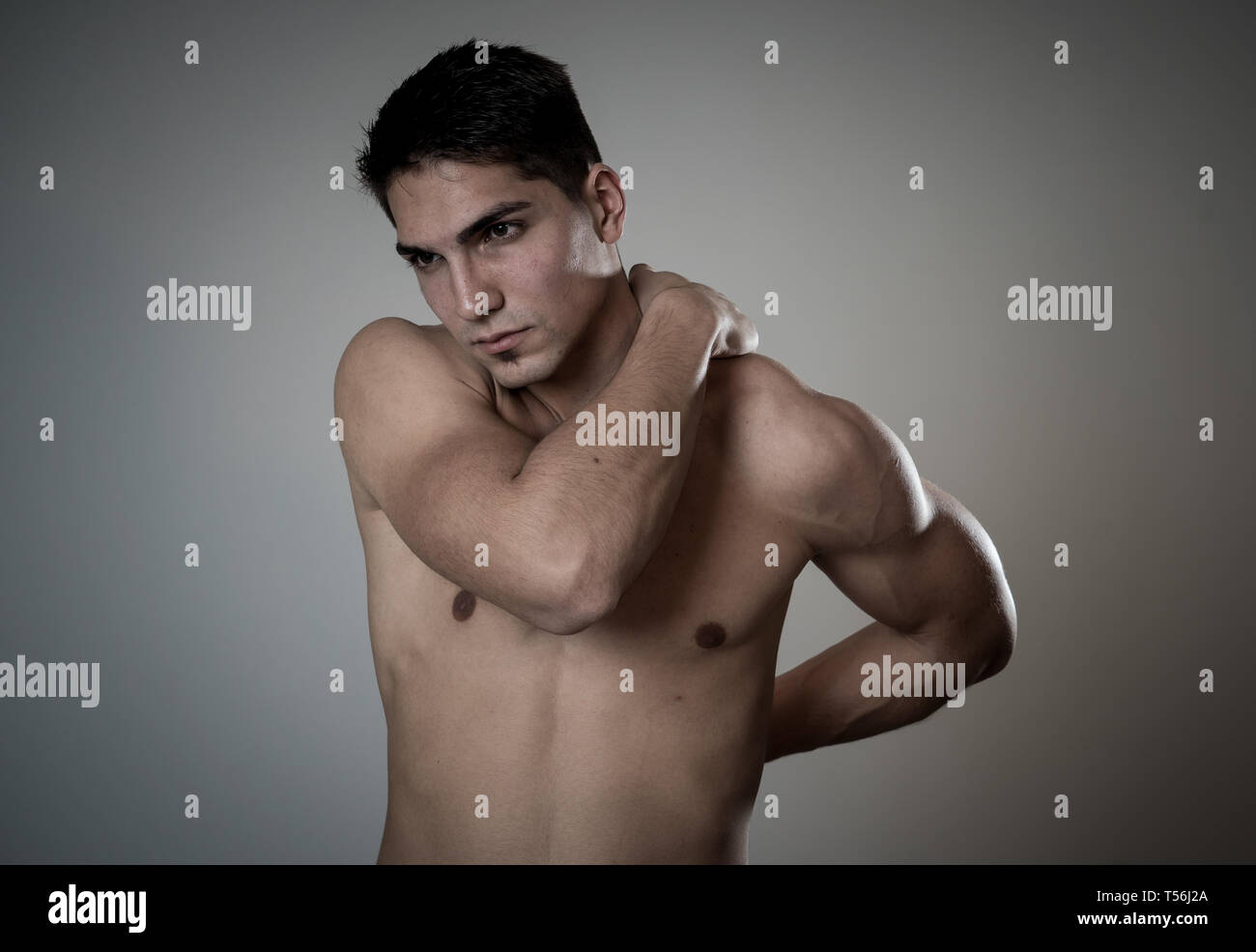 Young muscular fitness man touching and grabbing his neck and lower ...