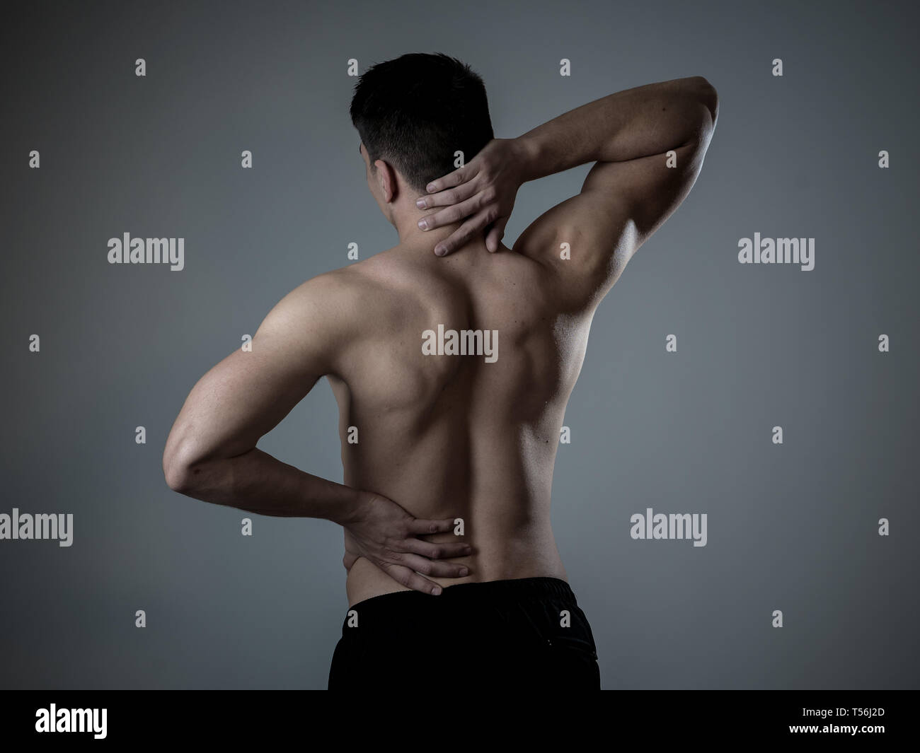 Young muscular fitness man touching and grabbing his neck and lower ...