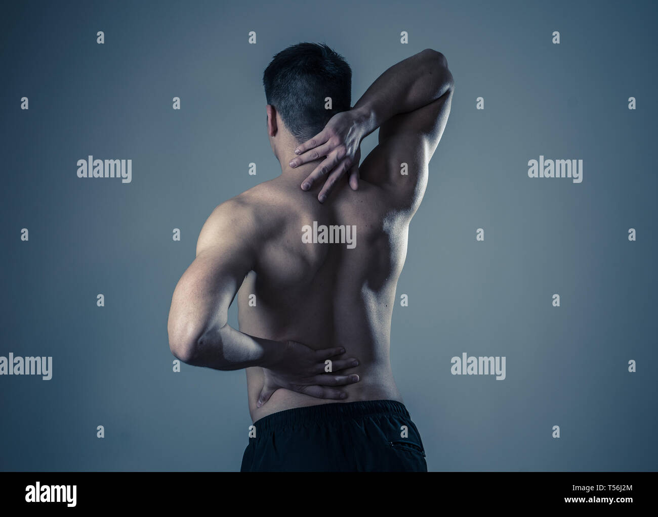 Young muscular fitness man touching and grabbing his neck and lower ...