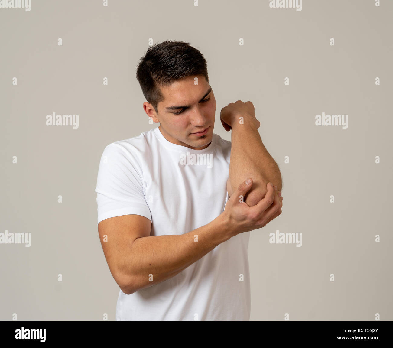 Muscular fitness young man touching and grabbing his elbow in pain ...