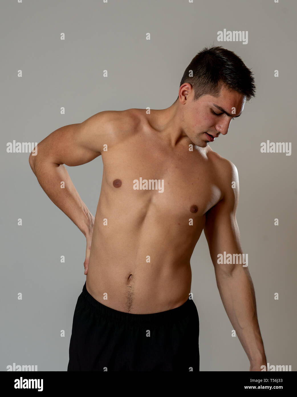 Young muscular fitness man touching and grabbing his lower back ...