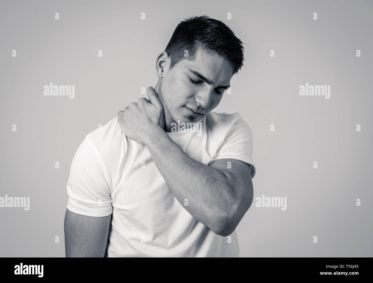 Young muscular fitness man touching and grabbing his neck and upper ...