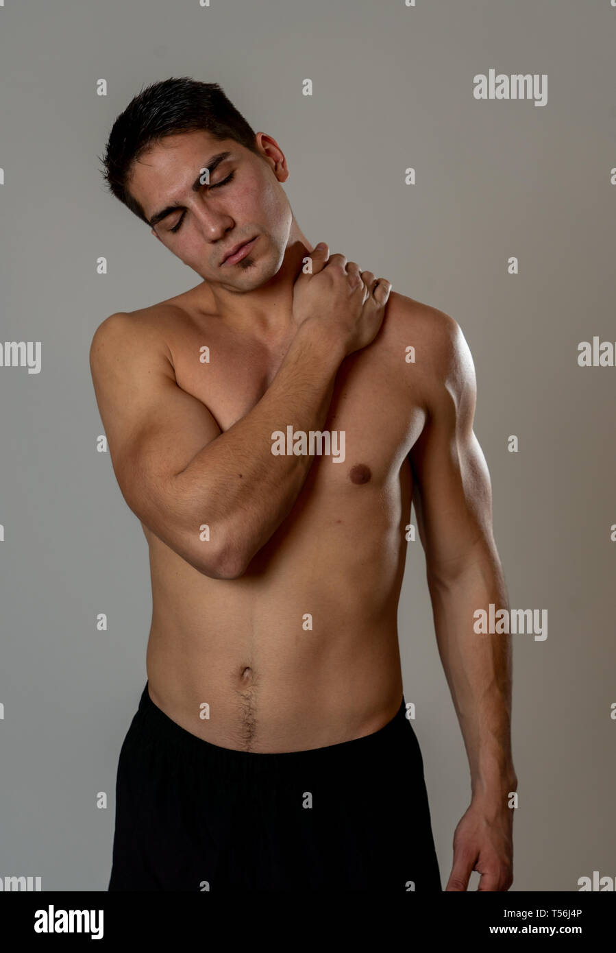 Young muscular fit man touching and grabbing neck and upper back ...