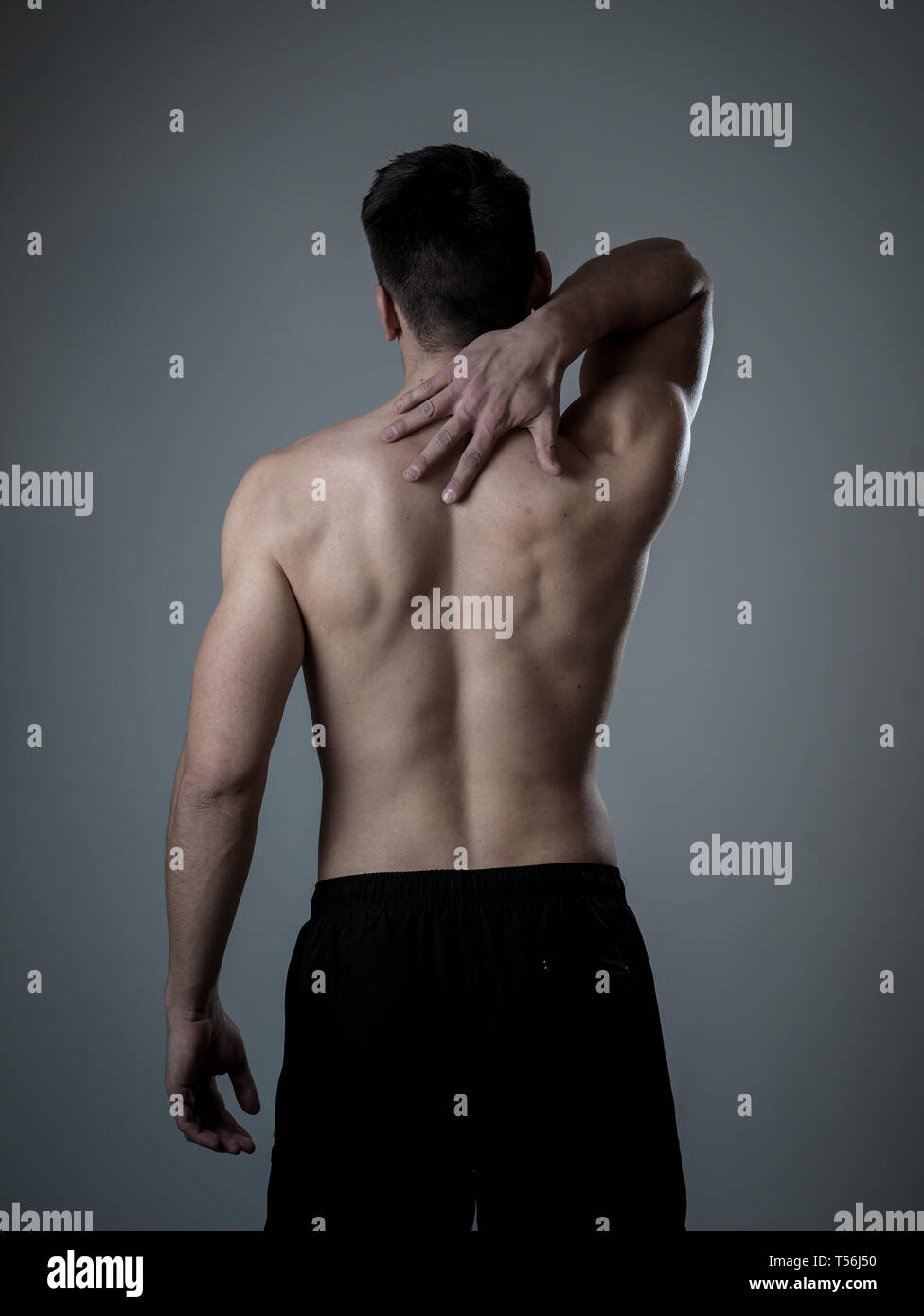 Young muscular fit man touching and grabbing neck and upper back ...