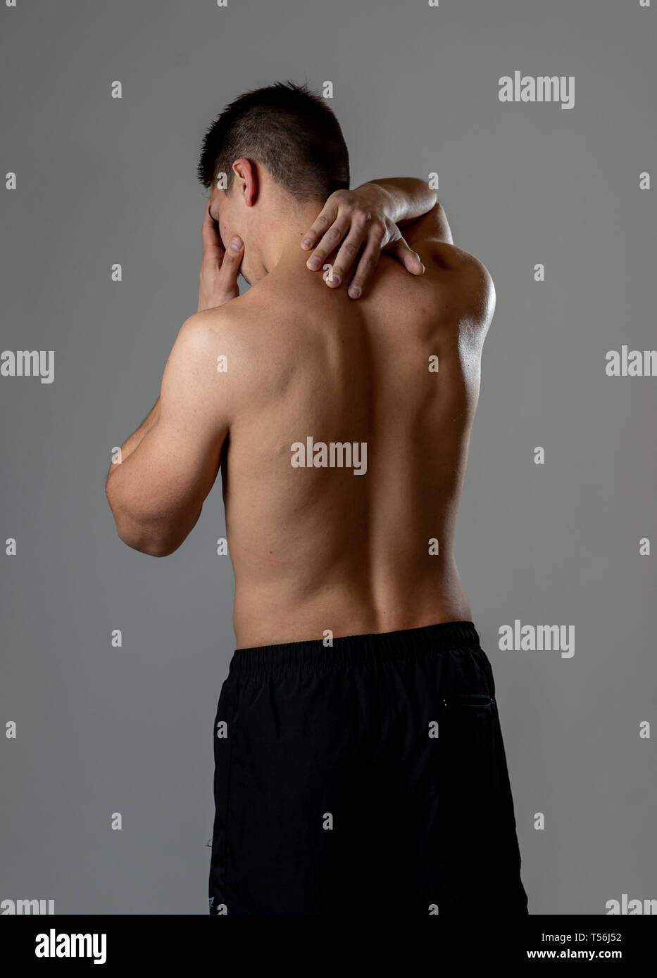 Young muscular fit man touching and grabbing neck and upper back ...