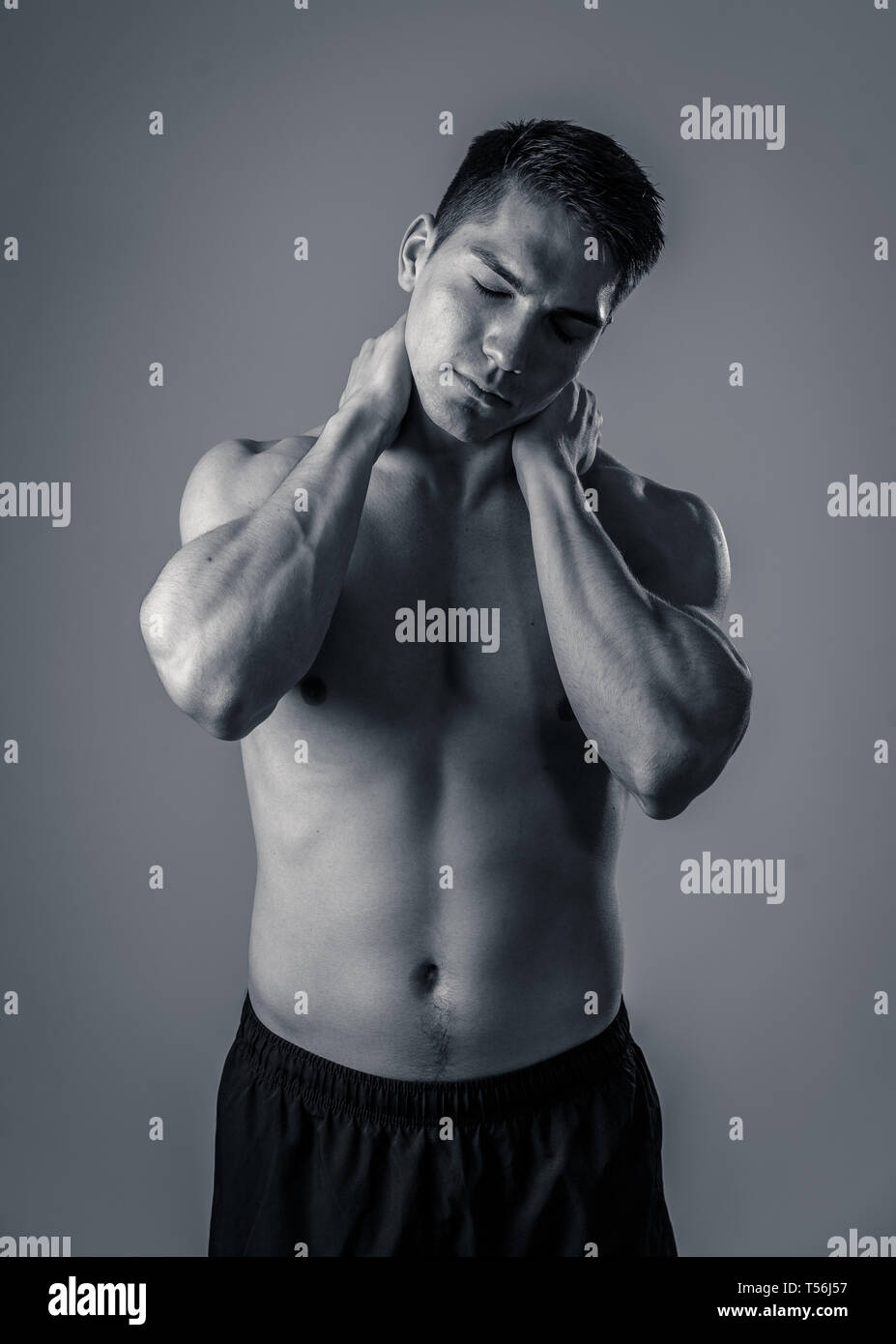 Young muscular fit man touching and grabbing neck and upper back ...