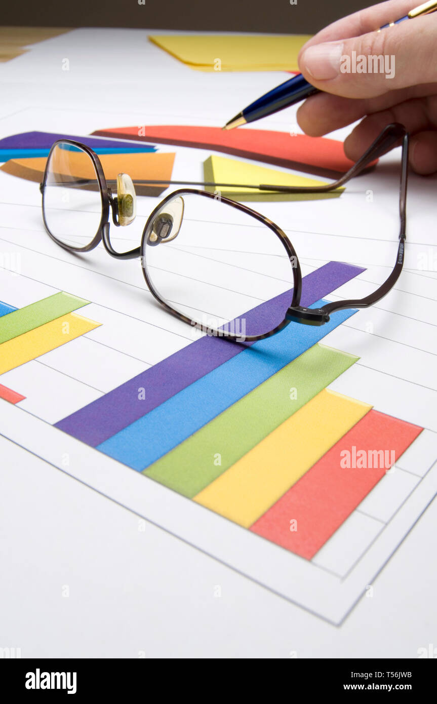 Reading Glasses, Business Graphs and Human Hand Writing Stock Photo - Alamy