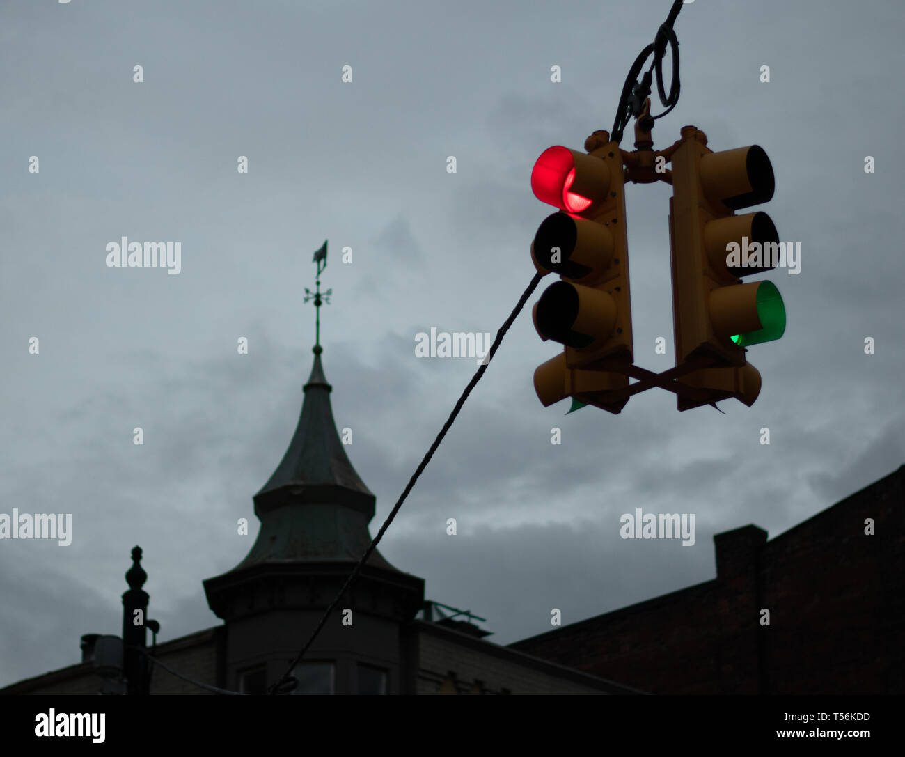 Traffic light at an intersection with building and cloudy weather ...