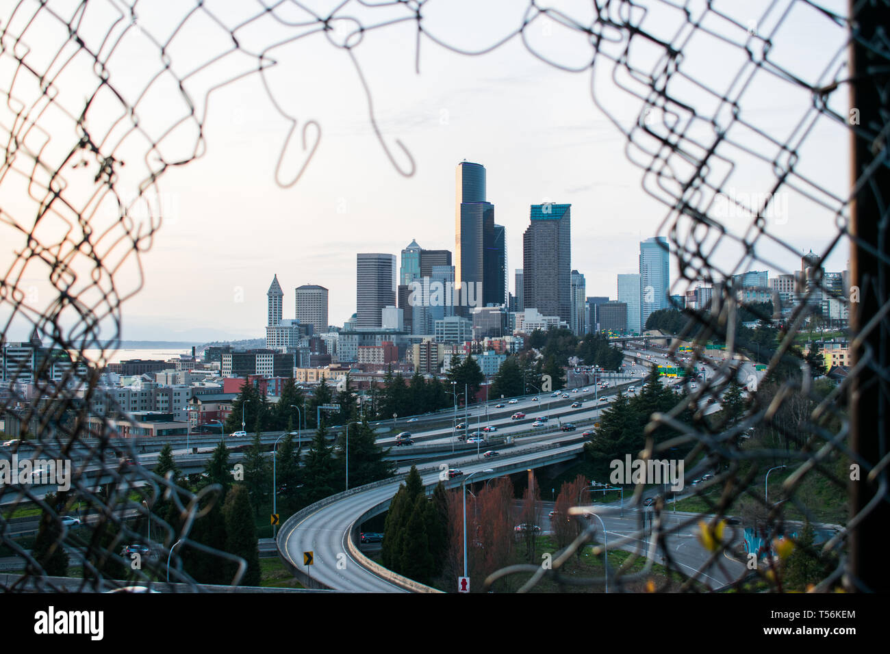 city buildings and highway through hole in fence Stock Photo - Alamy