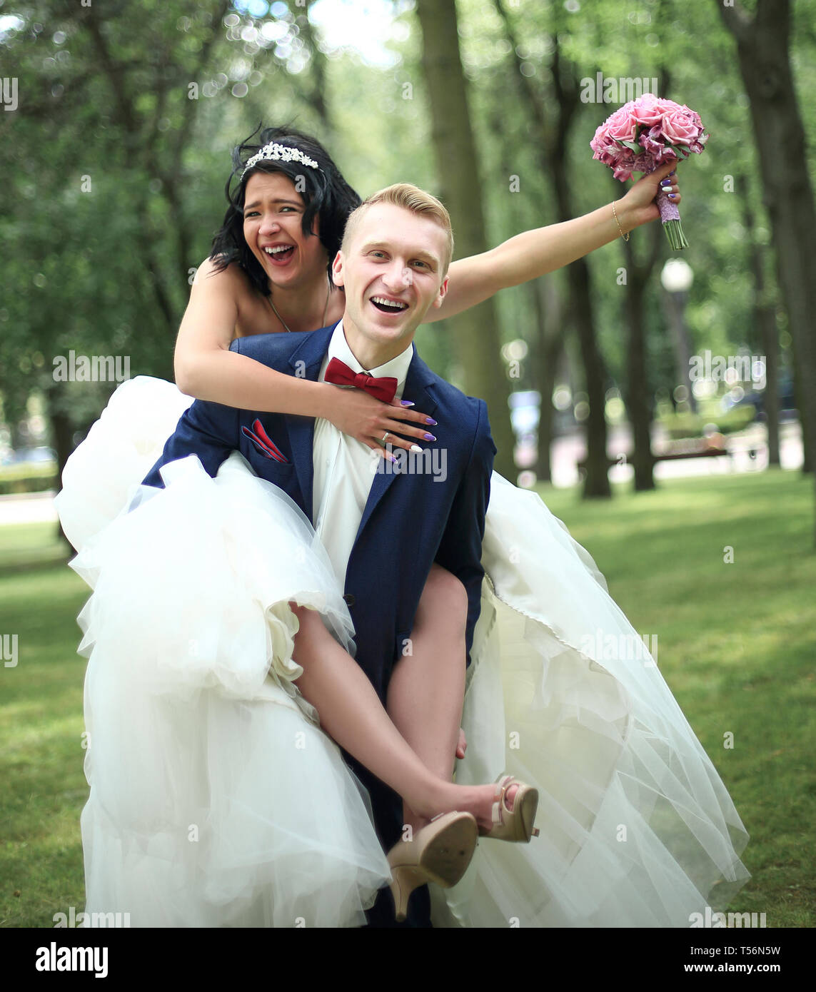 Handsome groom carrying bride hi-res stock photography and images - Alamy