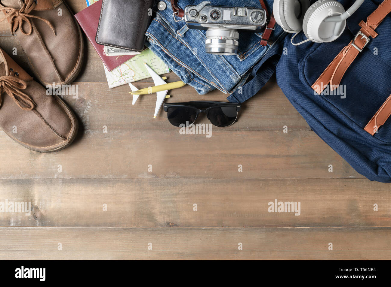 prepare backpack accessories and travel items on wood background with ...