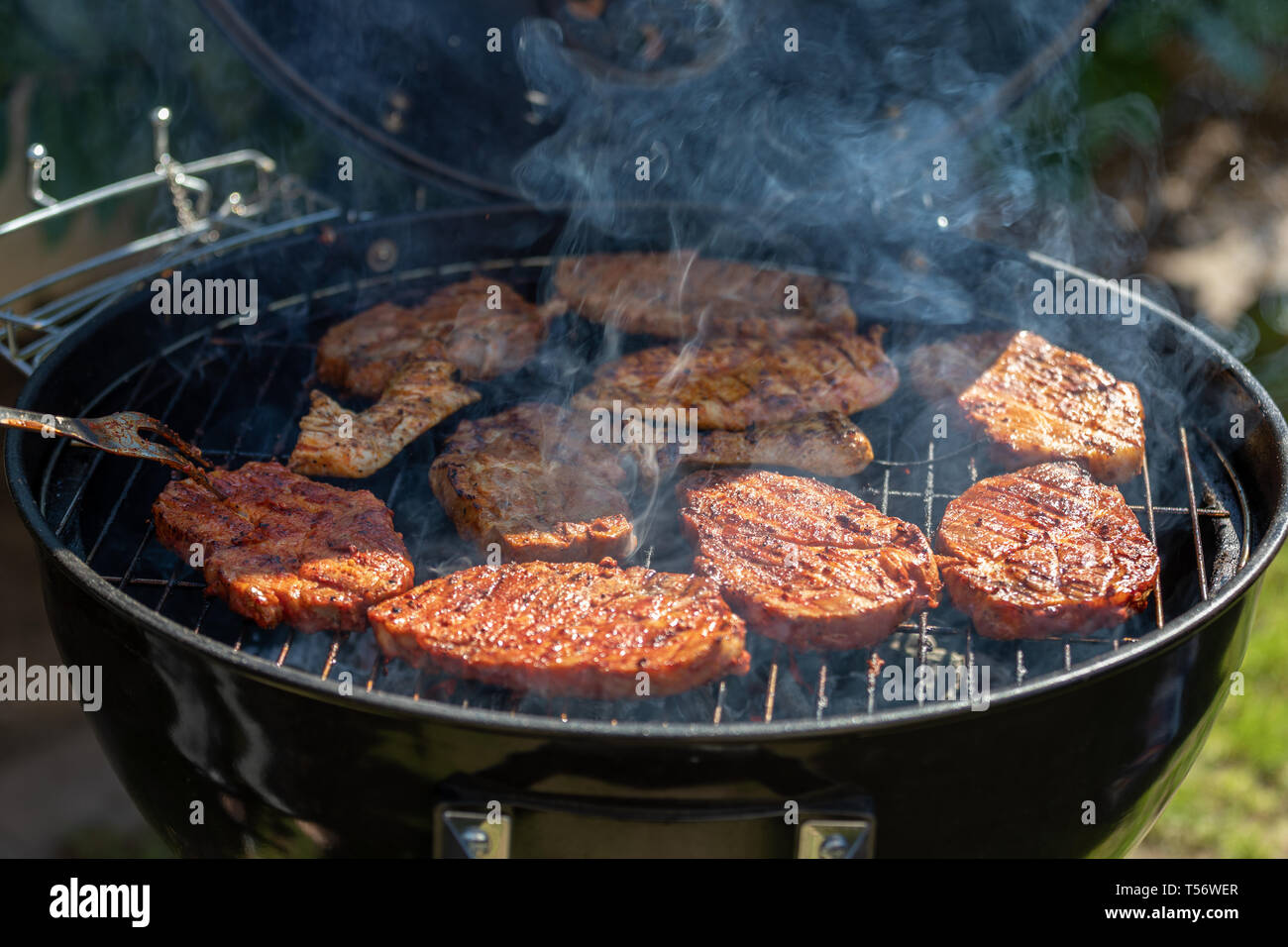 steaks cooking over flaming grill Stock Photo - Alamy