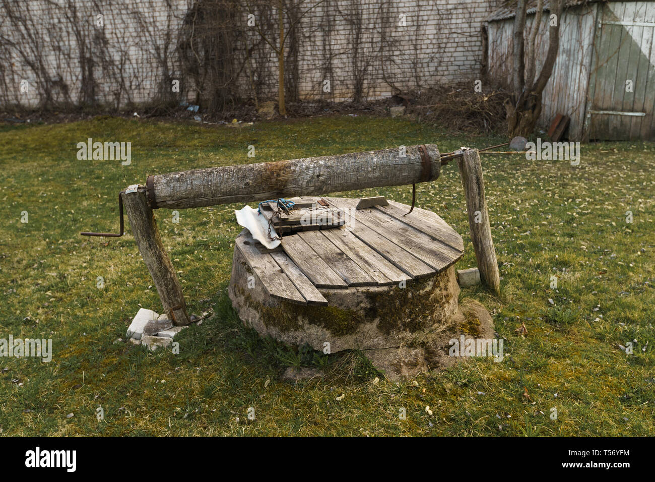 Small old well wooden on grass near a wooden werehouse Stock Photo - Alamy