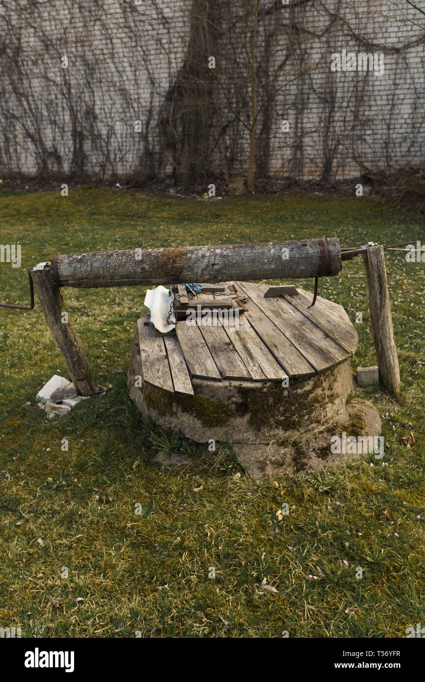 Small old well wooden on grass near a wooden werehouse Stock Photo - Alamy