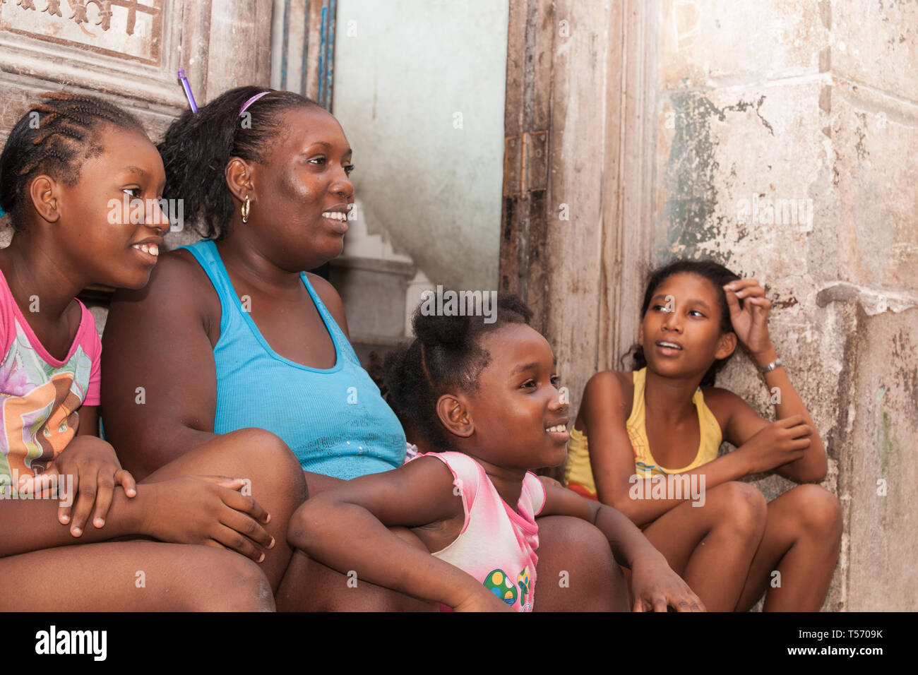 HAVANA CUBA - JULY 7 2012; Mother and three daughter sit on doorstep on ...