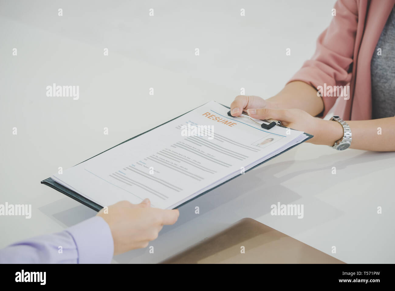 Woman is handing job resume to a HR officer Stock Photo - Alamy