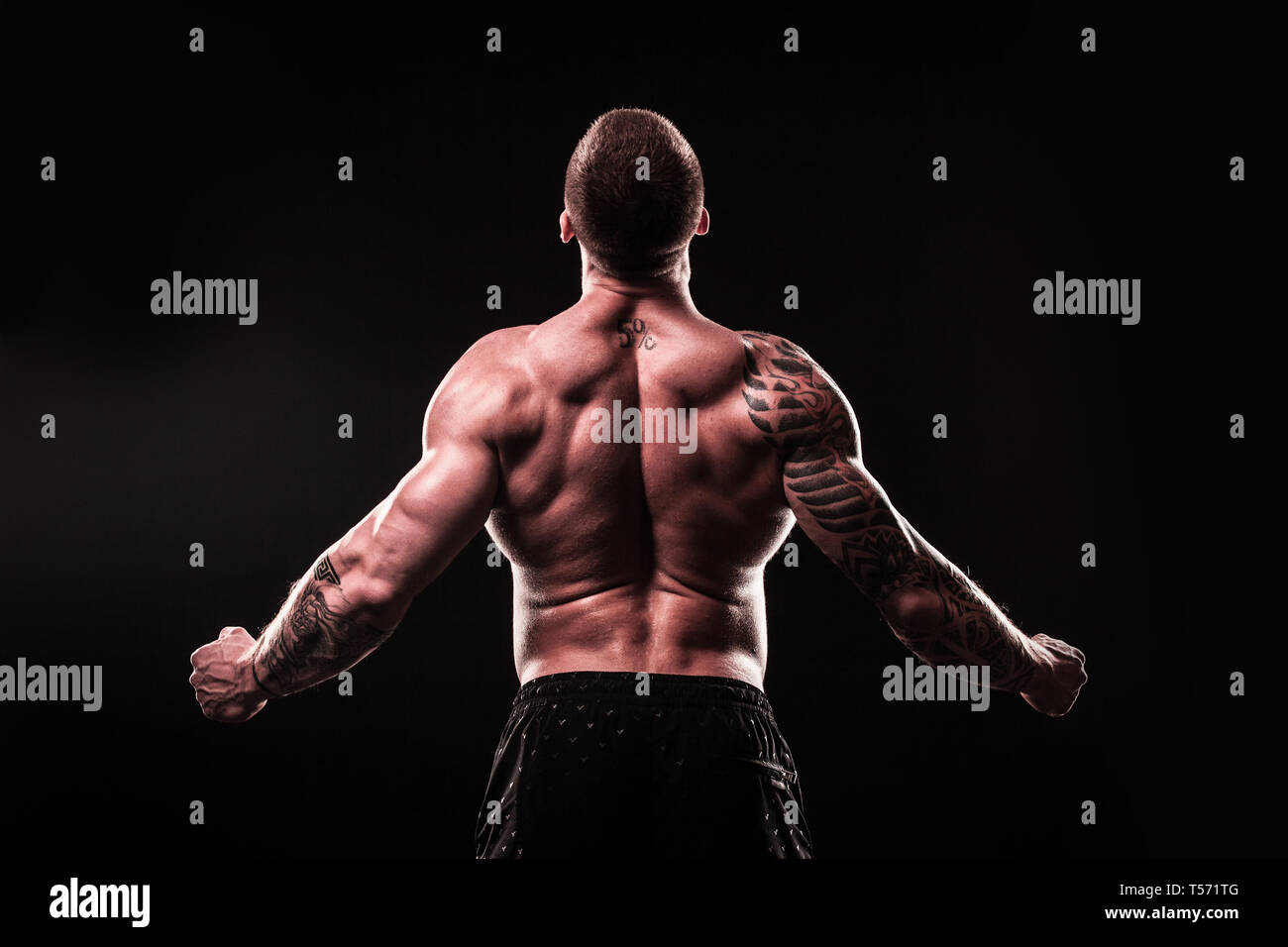 rear view. male bodybuilder looking at copy space.isolated on black ...